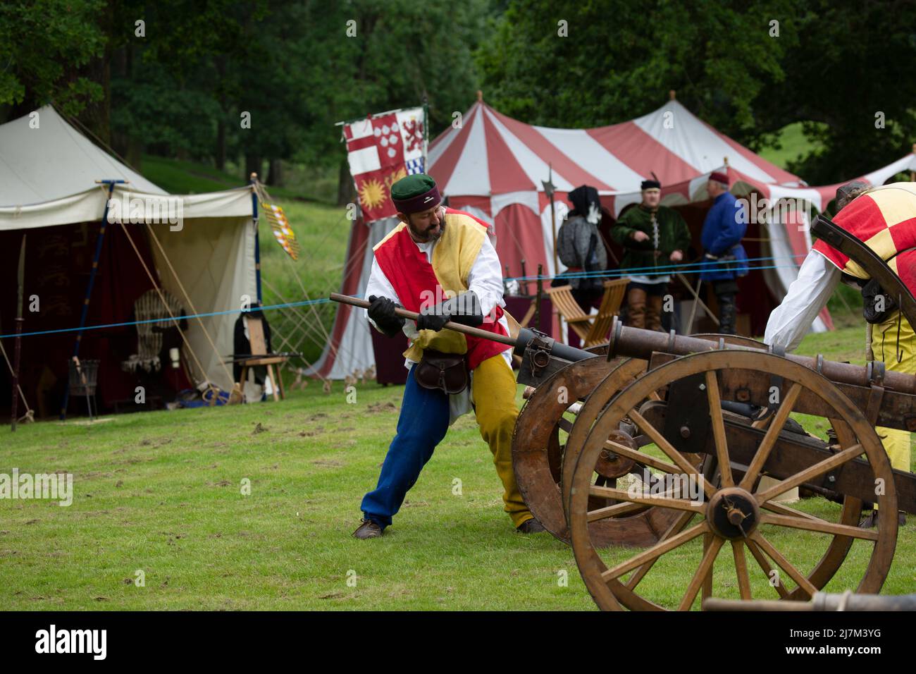 men and women firing muskets and wooden cannons during a re enactment ...