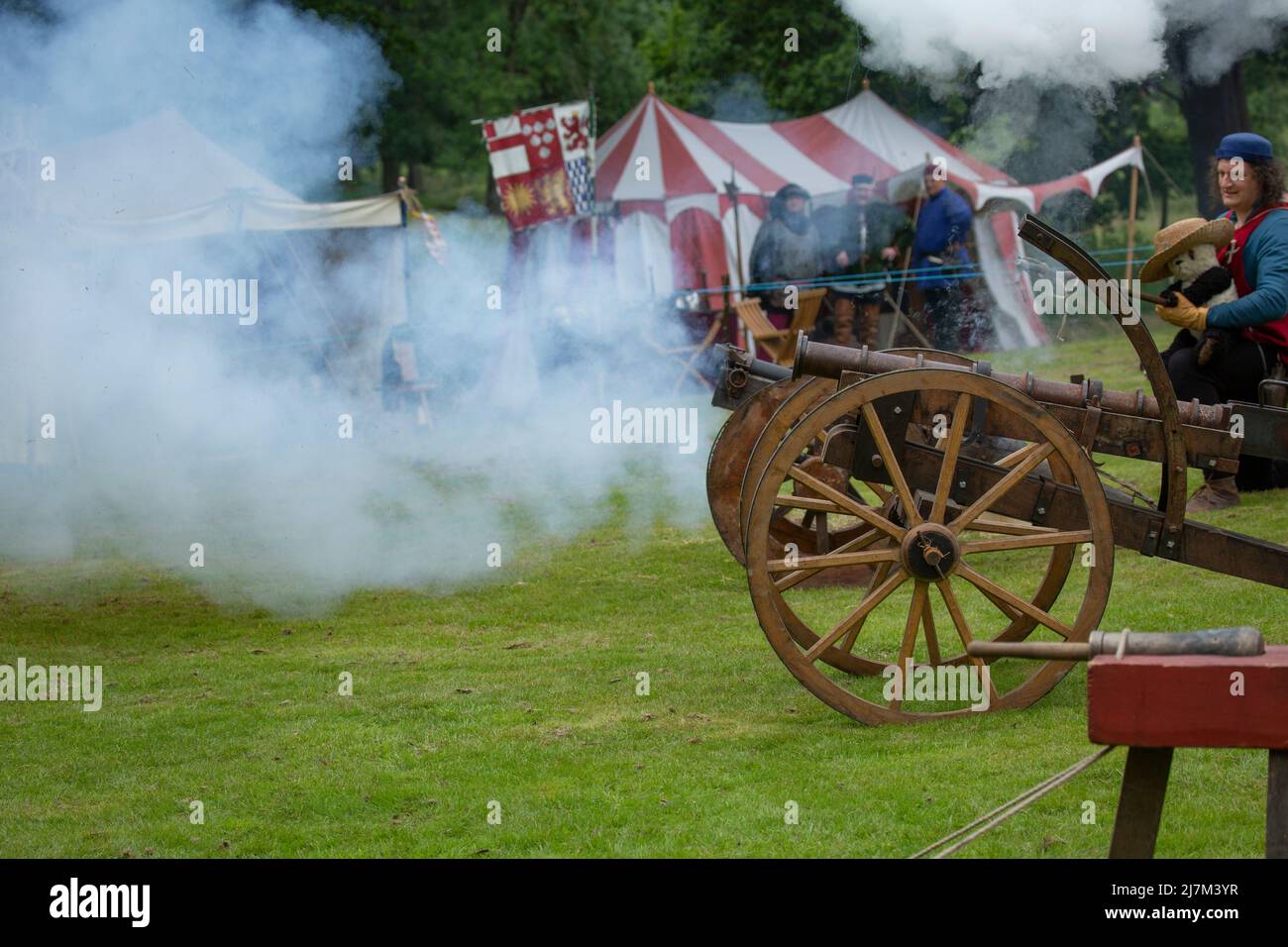 men and women firing muskets and wooden cannons during a re enactment ...