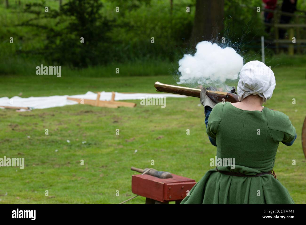 men and women firing muskets and wooden cannons during a re enactment ...