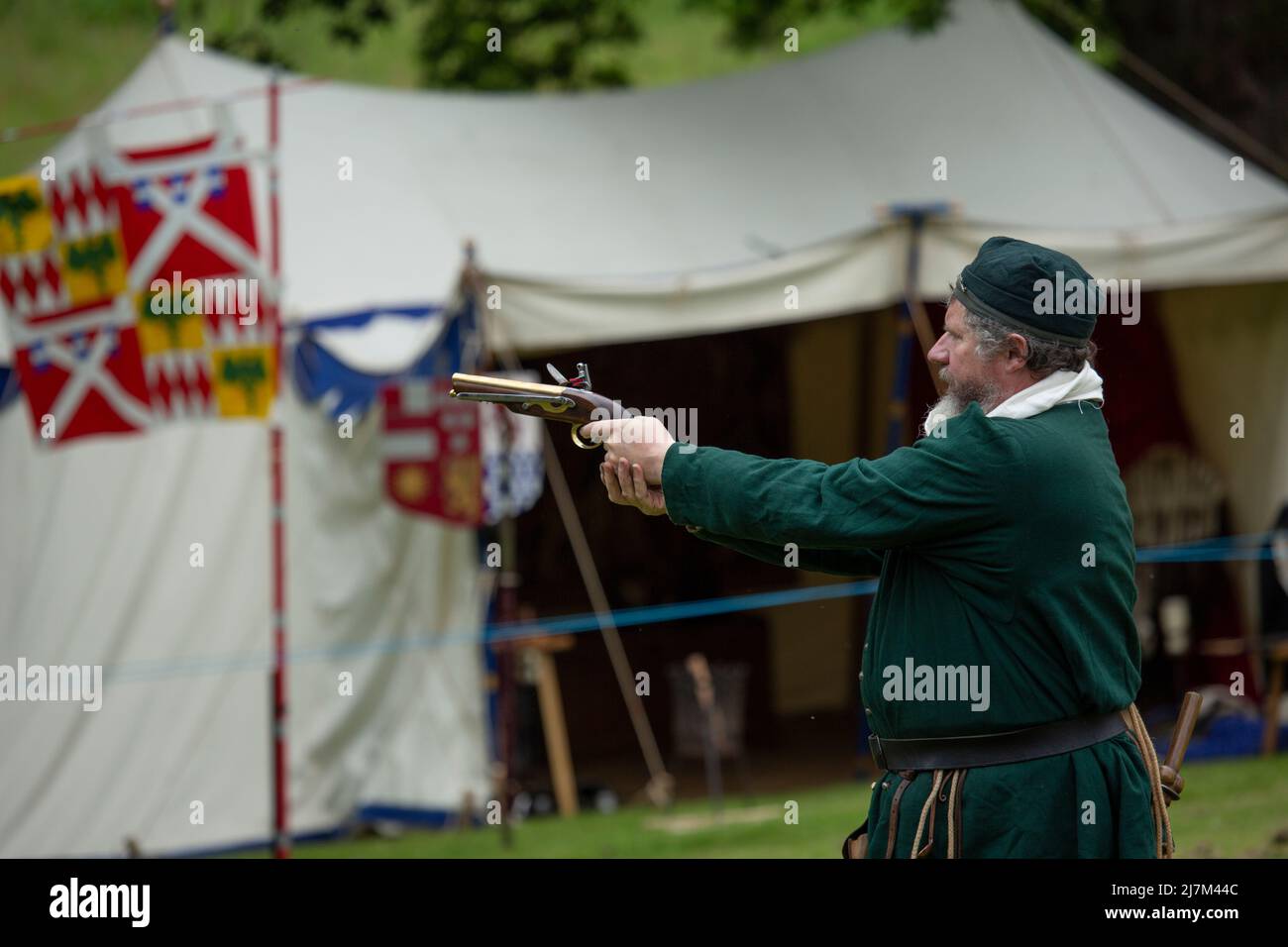 men and women firing muskets and wooden cannons during a re enactment ...
