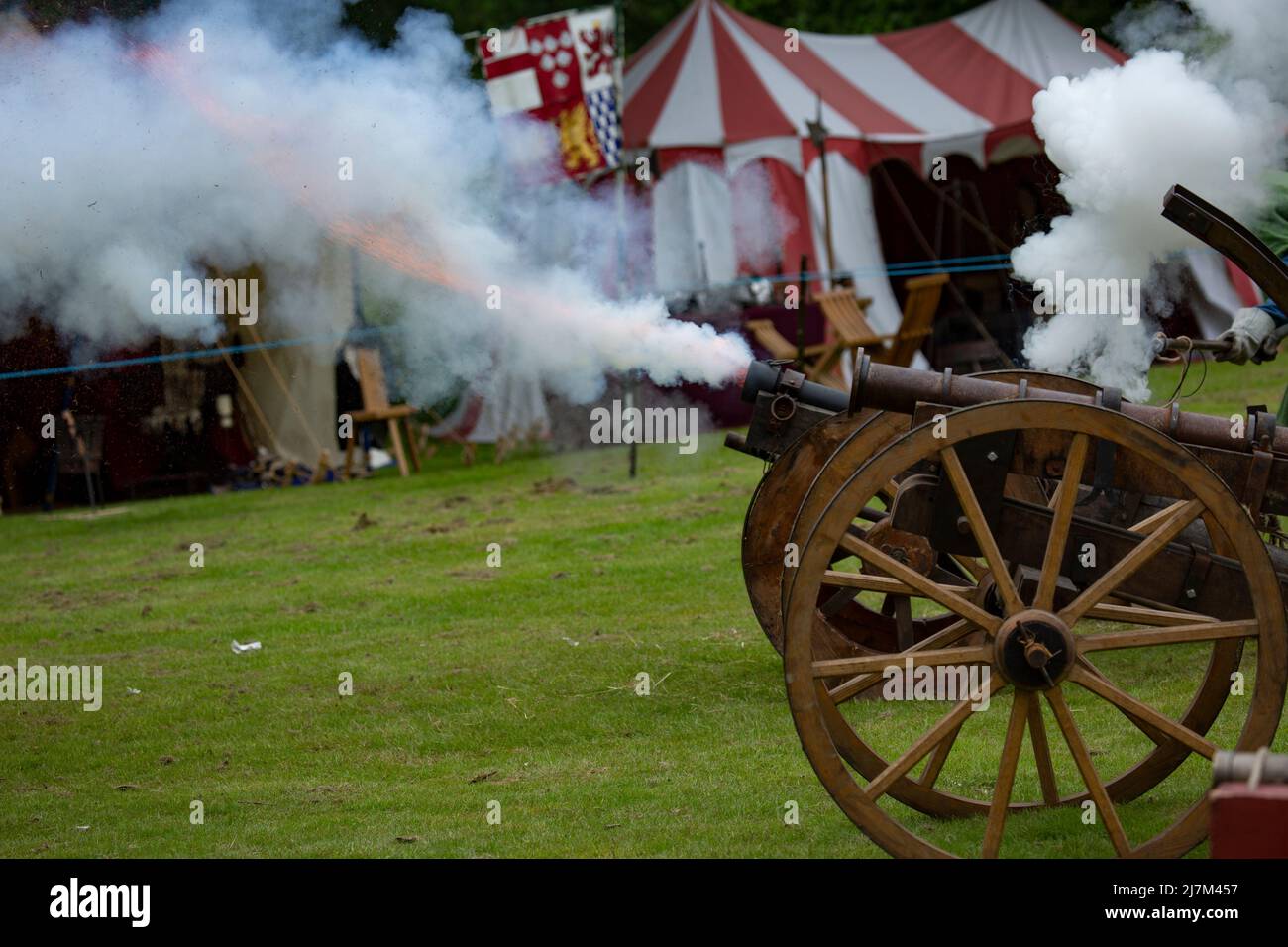 men and women firing muskets and wooden cannons during a re enactment ...