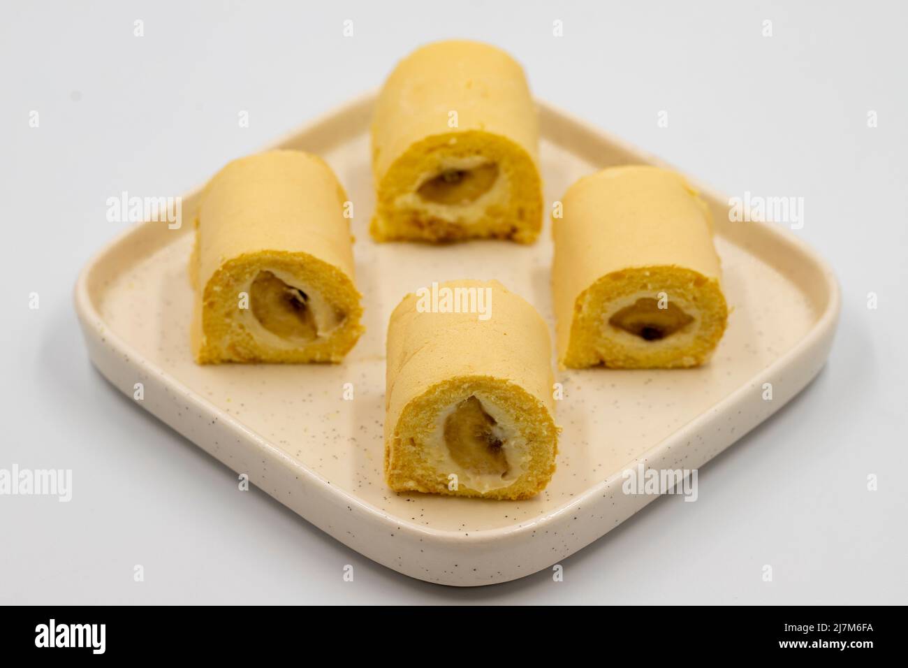 Banana roll cake. Roll cake with banana filling on a white background ...
