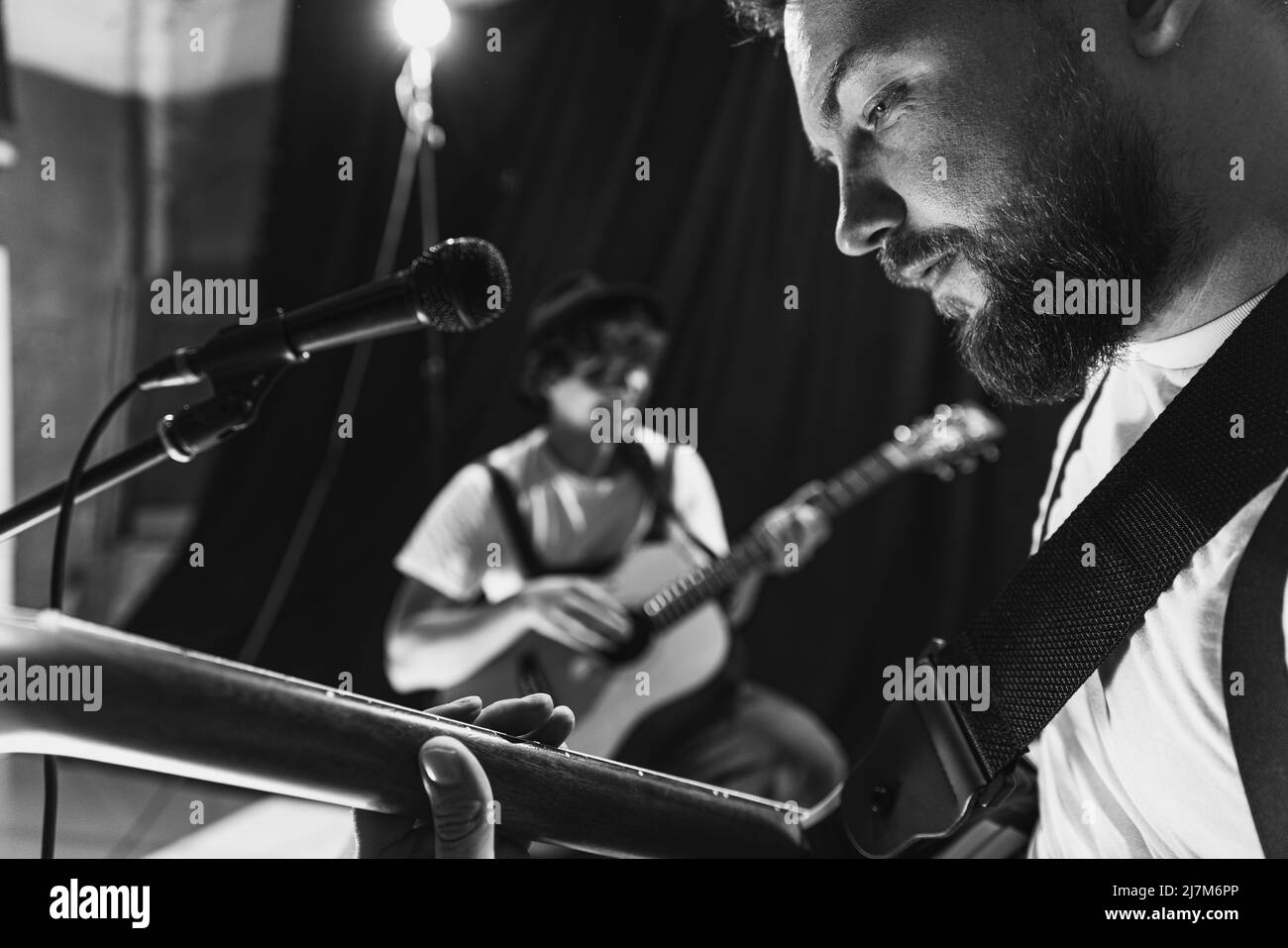 Close-up men, electric and acoustic guitar players at concert ...