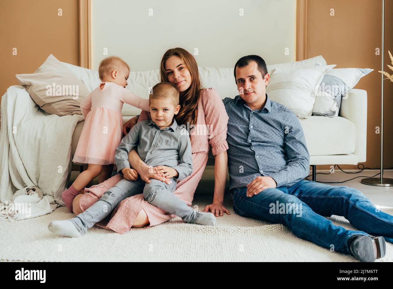 Young parents sit on the floor with small children Stock Photo - Alamy