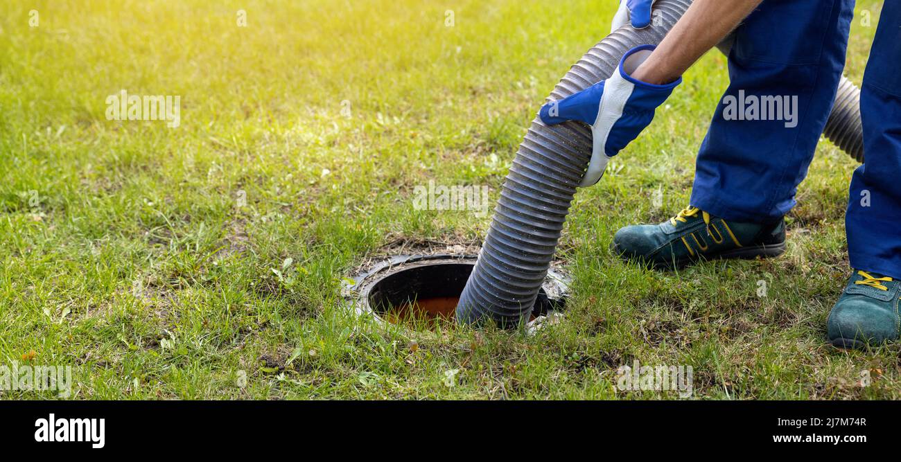 man pumping out house septic tank. drain and sewage cleaning service ...
