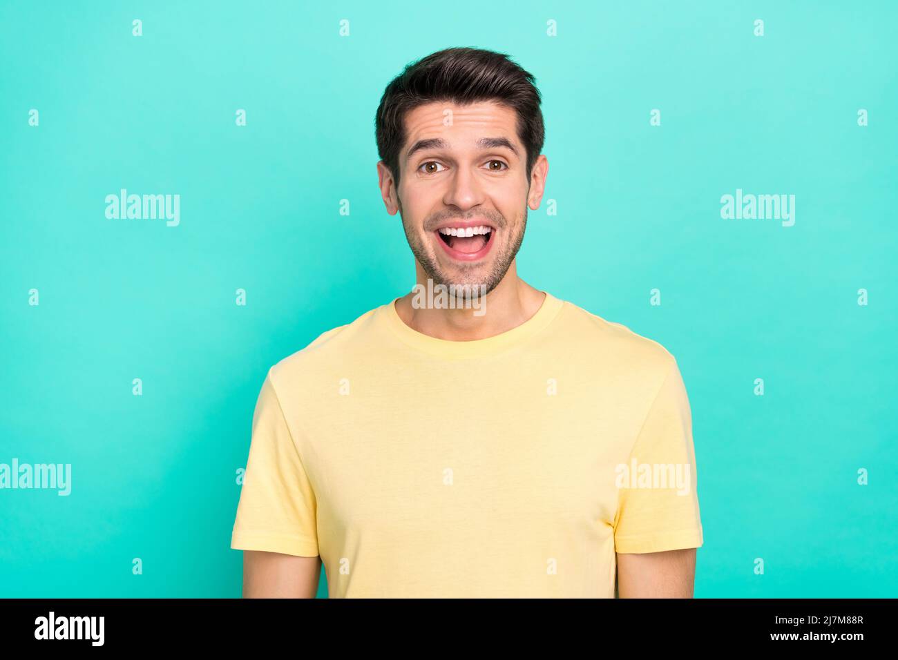 Photo of impressed brunet millennial guy wear yellow t-shirt isolated ...