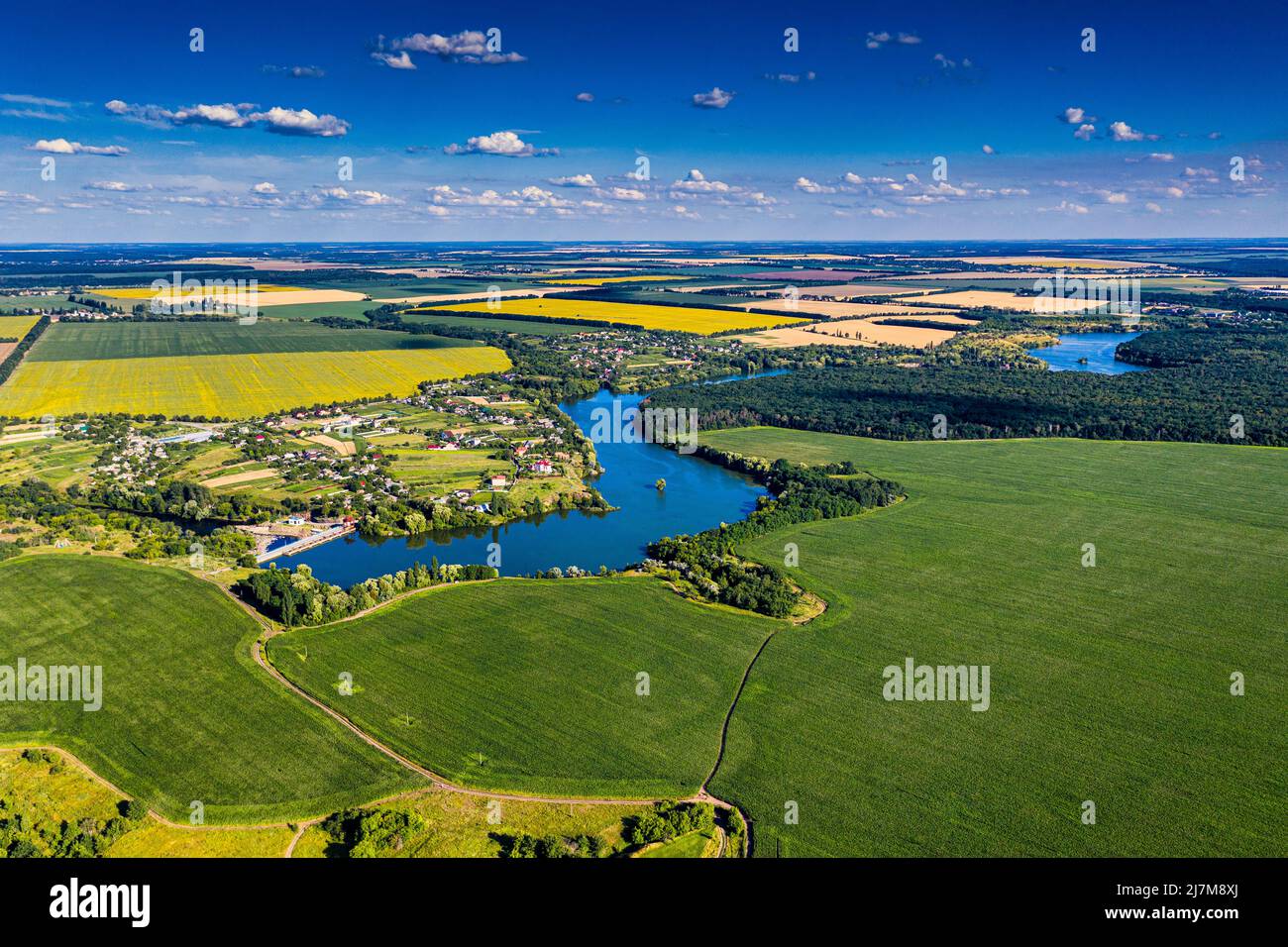 Top view of green fields. Beautiful forest, blue sky, clouds. River flows Stock Photo - Alamy
