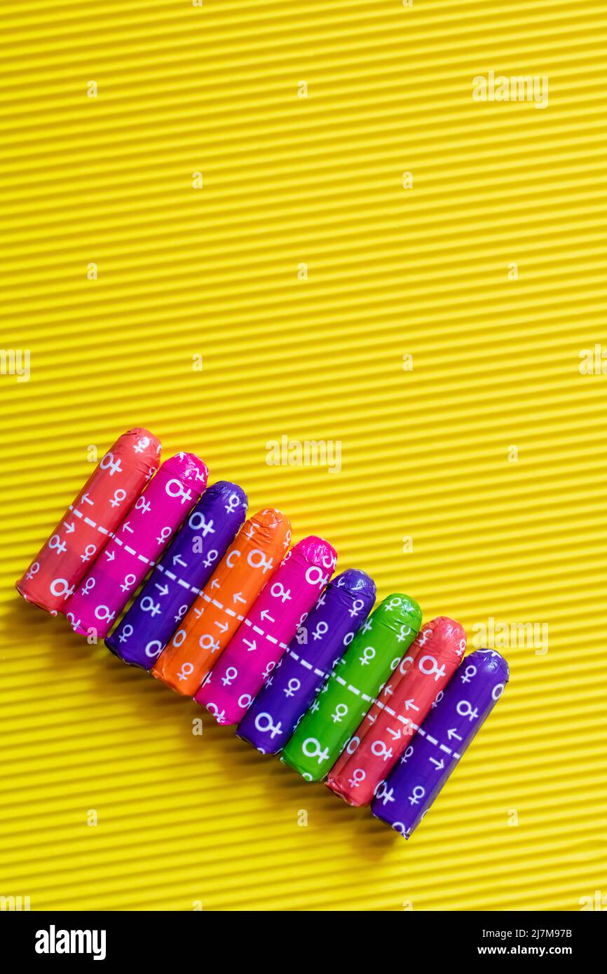 top view of packed multicolored tampons with female signs on yellow ...