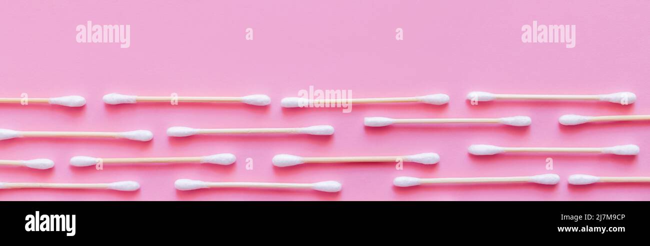 top view of rows of hygienic cotton swabs on pink background, banner ...
