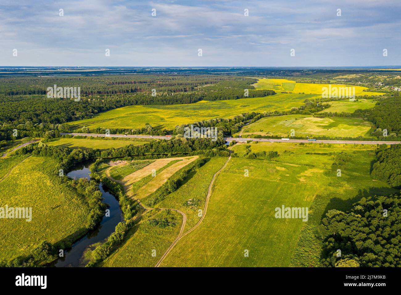 Top view of green fields. Beautiful forest, blue sky, clouds. River flows Stock Photo - Alamy