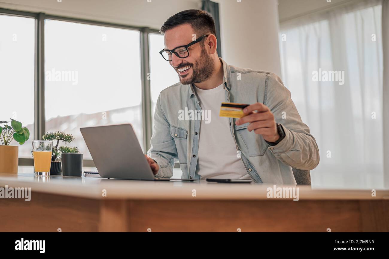 Curious adult man, looking at his bank balance, online, using his ...