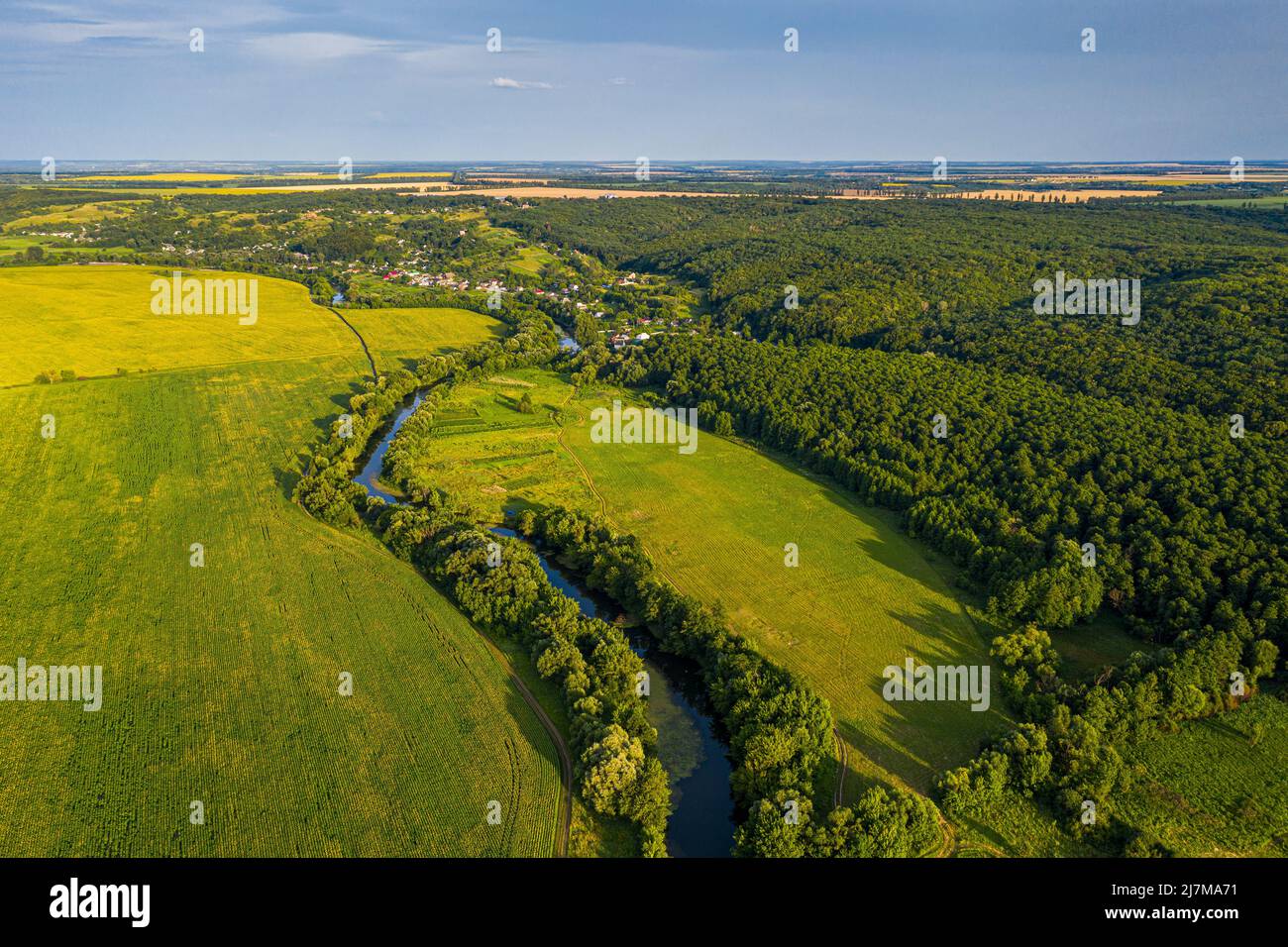 Top view of green fields. Beautiful forest, blue sky, clouds. River flows Stock Photo - Alamy