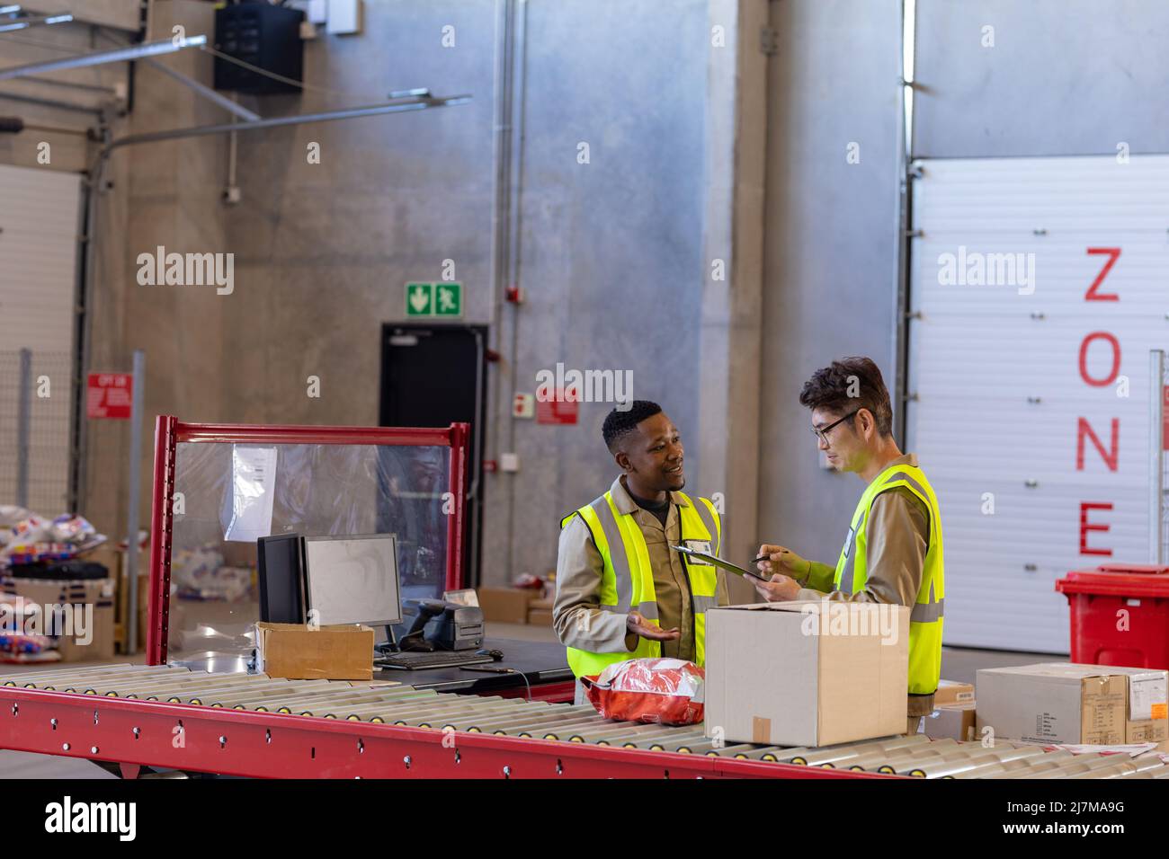 African american young male worker talking with asian mature man ...