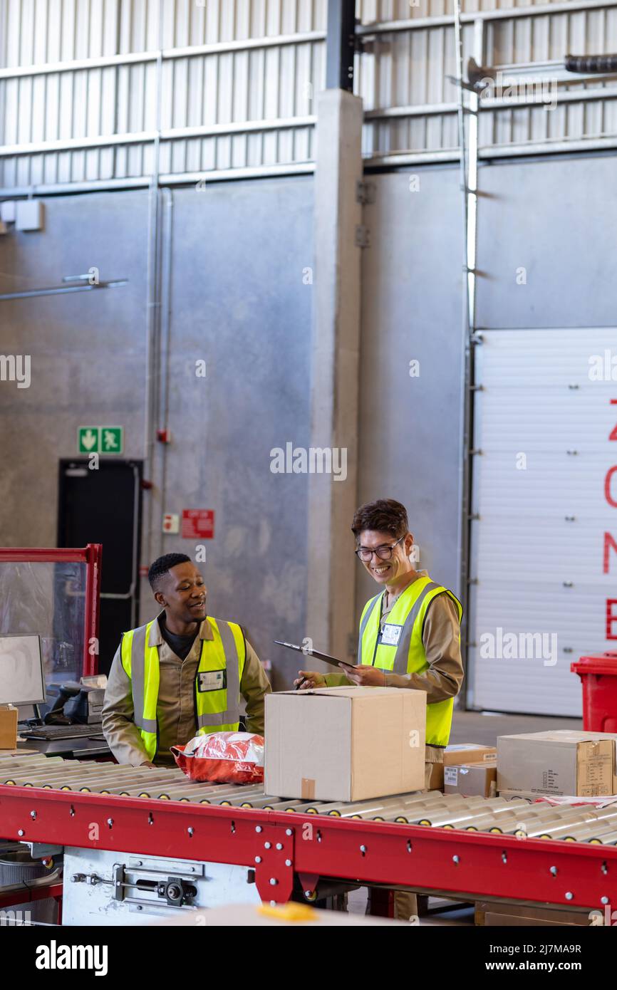 Smiling african american young man and asian mature male coworker ...