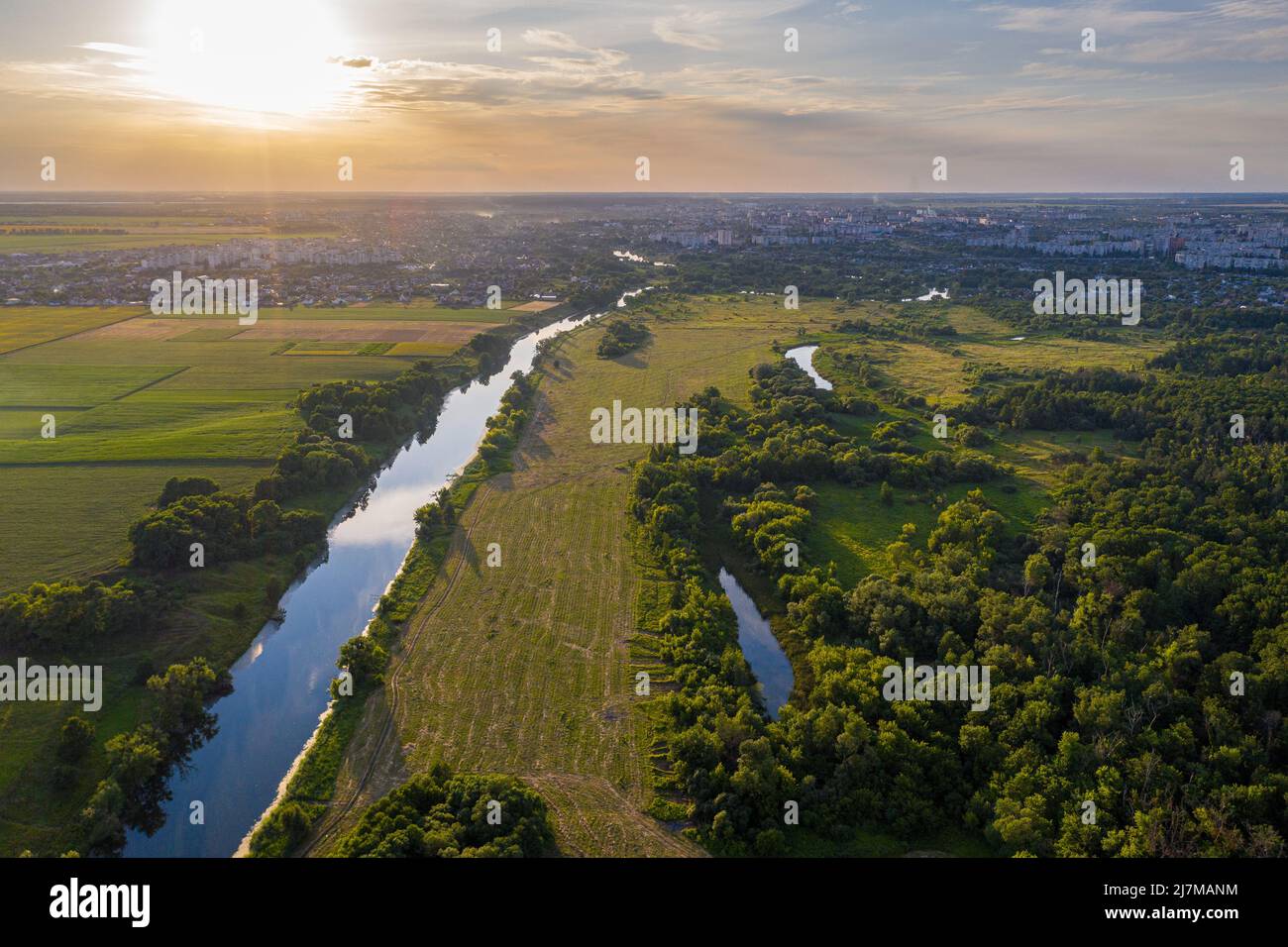 Top view of green fields. Beautiful forest, blue sky, clouds. River flows Stock Photo - Alamy