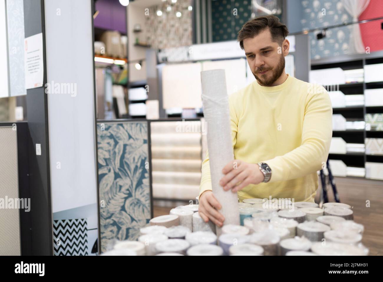 a man in a store of decorative building finishing materials chooses ...