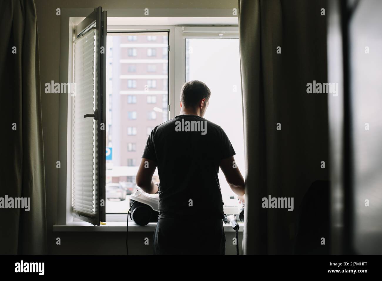 Man washing and cleaning window at home. Housework and housekeeping ...