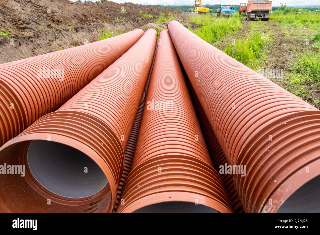 new sewer pipes brought to the construction site for laying in a trench ...