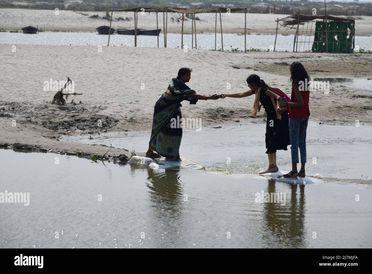 People crossing low water in the shallow riverbed in the bank of the ...