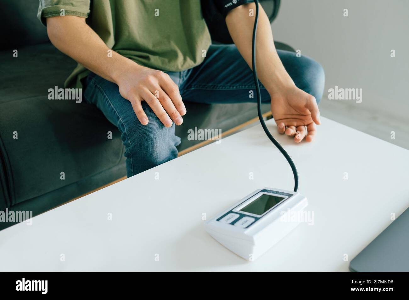 Blood pressure monitor, the young man put the bandage of the device on ...