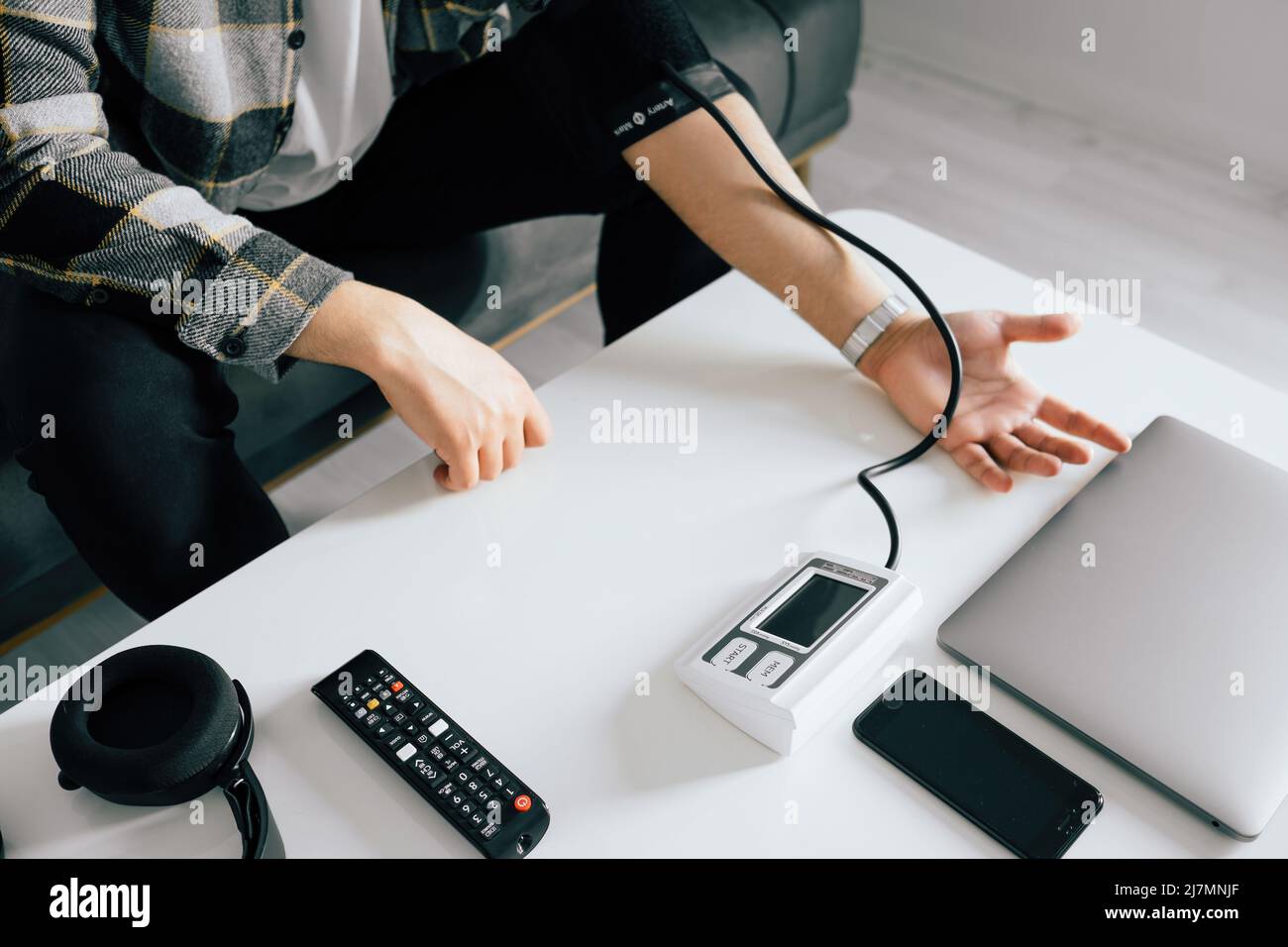 Blood pressure, young man checking his blood pressure at his desk ...