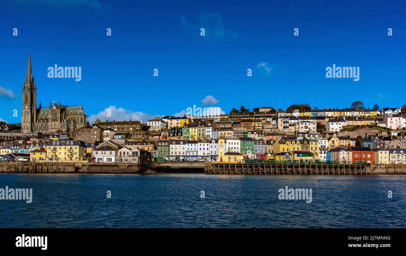 Church overlooking the coloured houses in a seaside town, Cobh, County ...