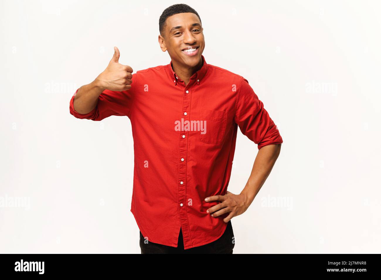 Cheerful African-American guy in red shirt showing thumb up isolated on ...