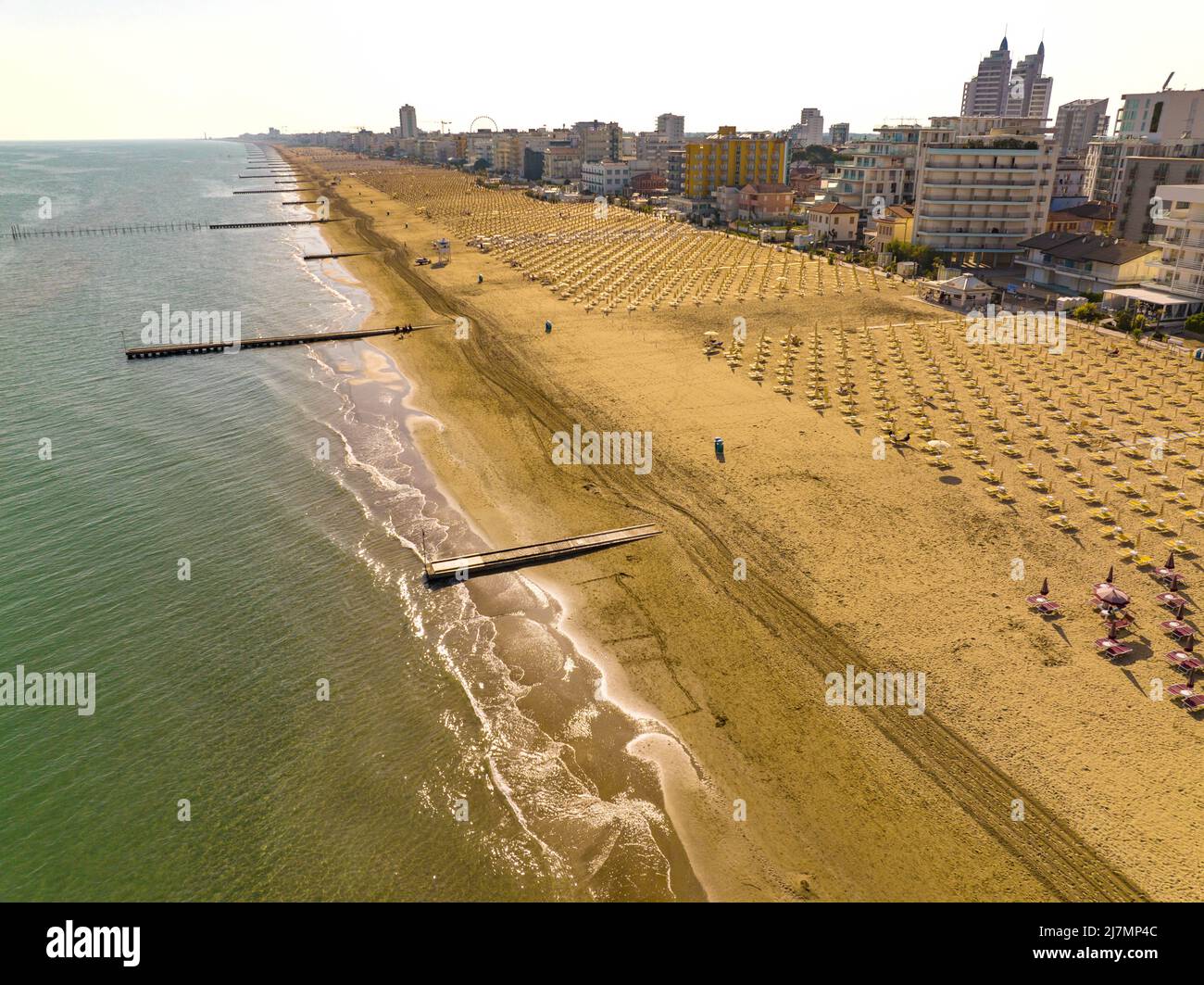 Golden beach of Jesolo village with bay and umbrellas at seaside from ...