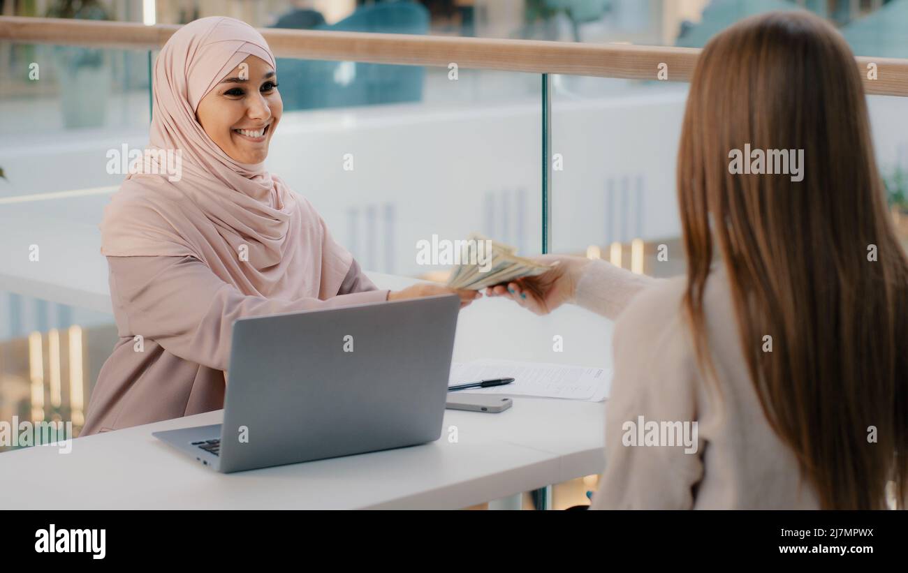 Young friendly smiling arab woman manager sits in office at desk ...