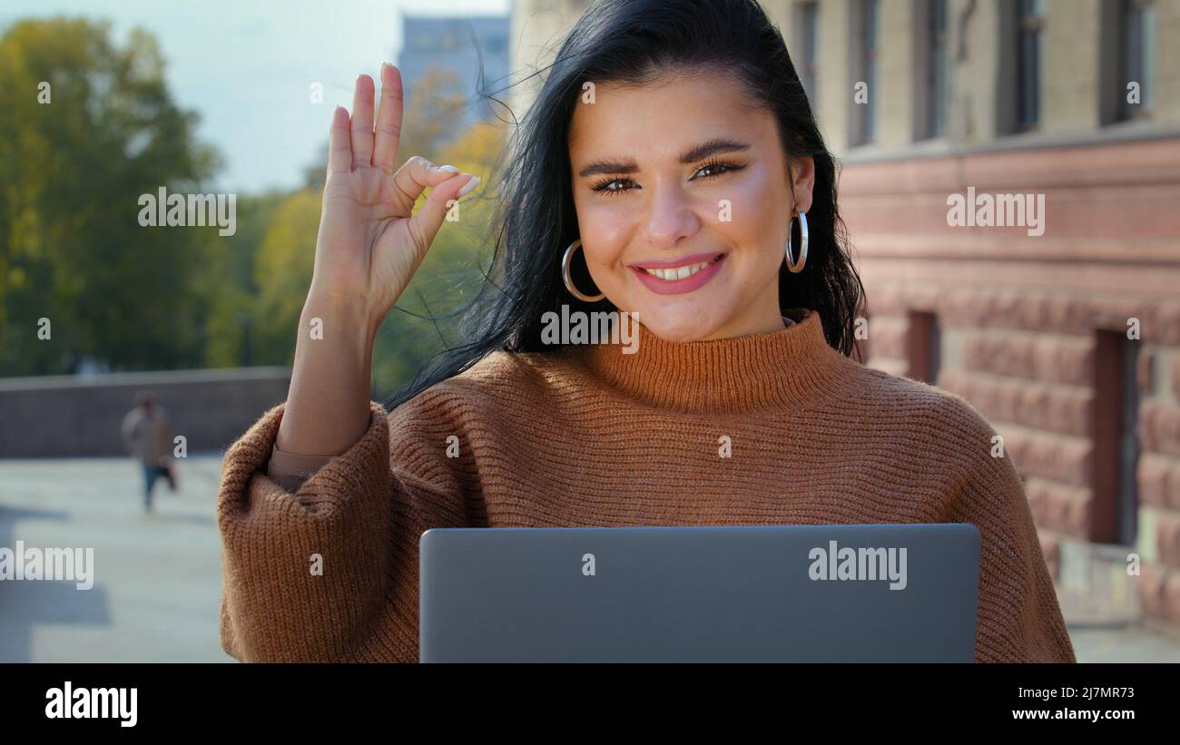 Girl freelancer student typing on laptop outdoors looking for useful ...