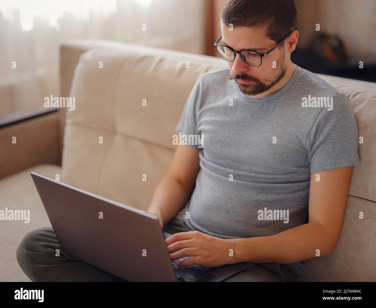Handsome young man using laptop computer at home. Student men in his ...