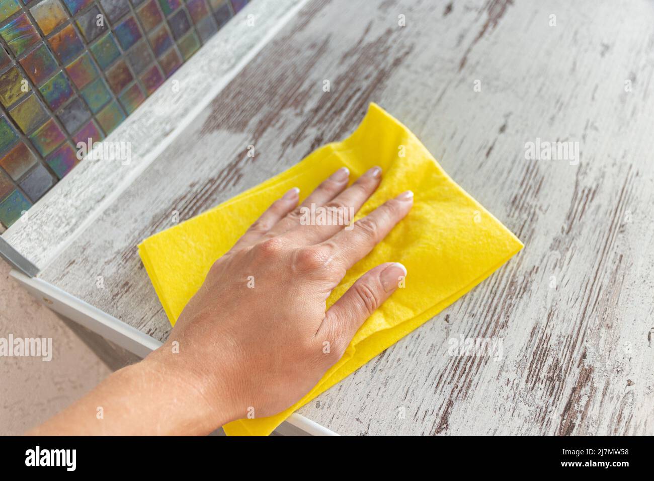 Cleaning yellow napkin in the hands of a woman. cleaning service. The ...
