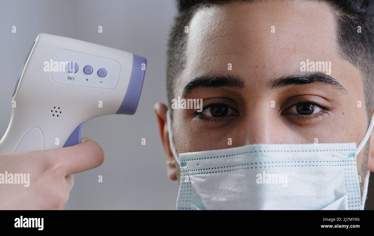 Close-up view infrared scanner on male customer's forehead arabian man ...