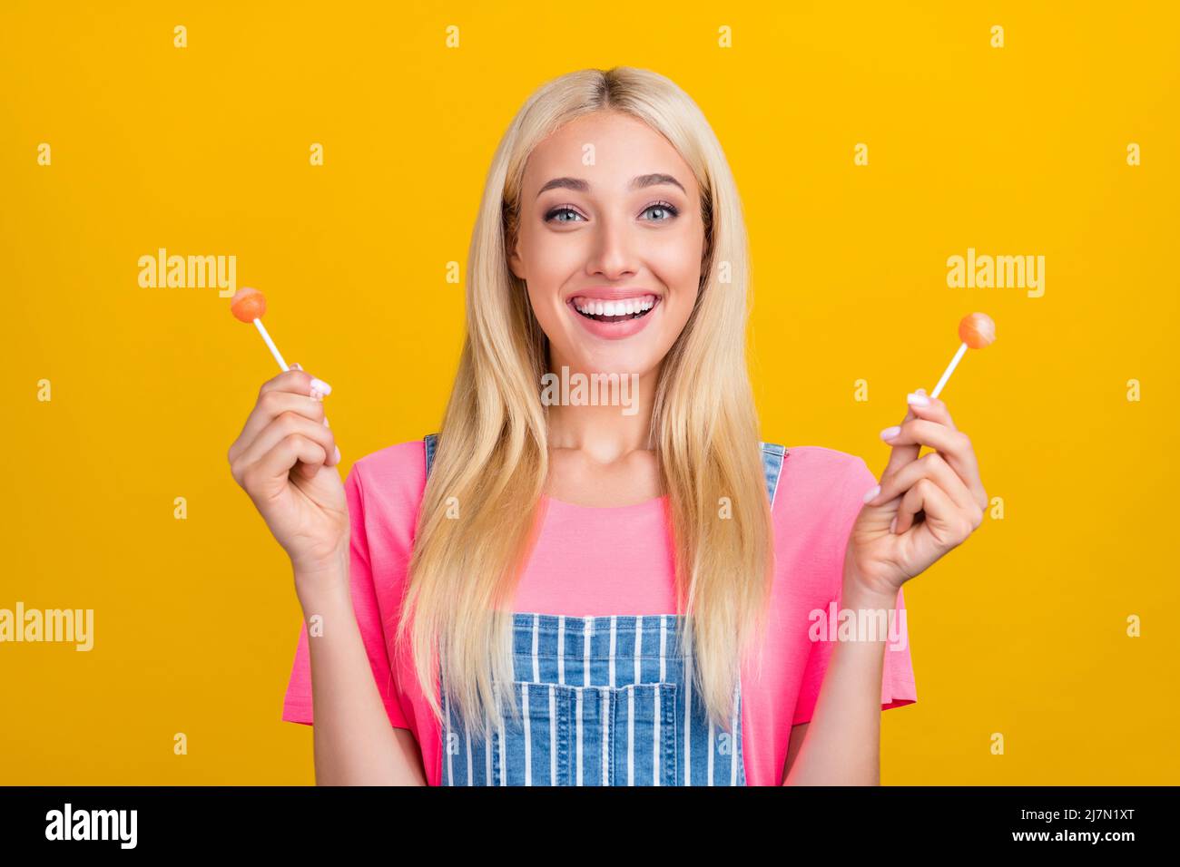 Portrait of attractive cheerful girly teenage girl eating candies ...