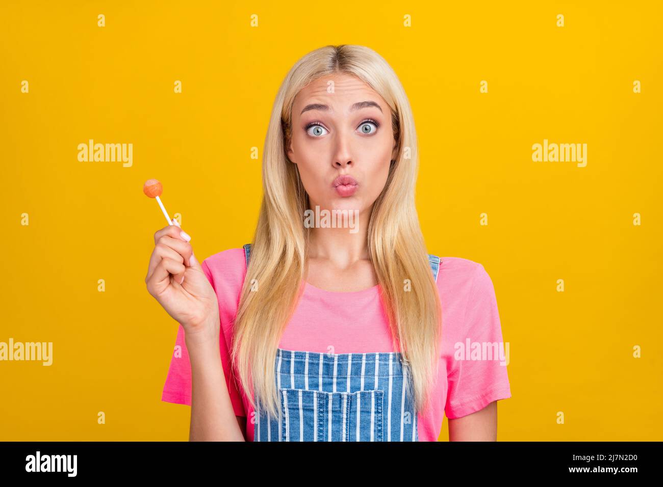 Portrait of attractive funny girly teenage girl licking candy staring ...