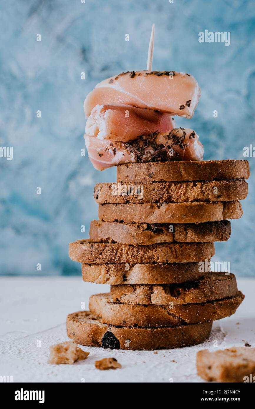 Food background. A tower of crispy toast with olives and ham and cream ...