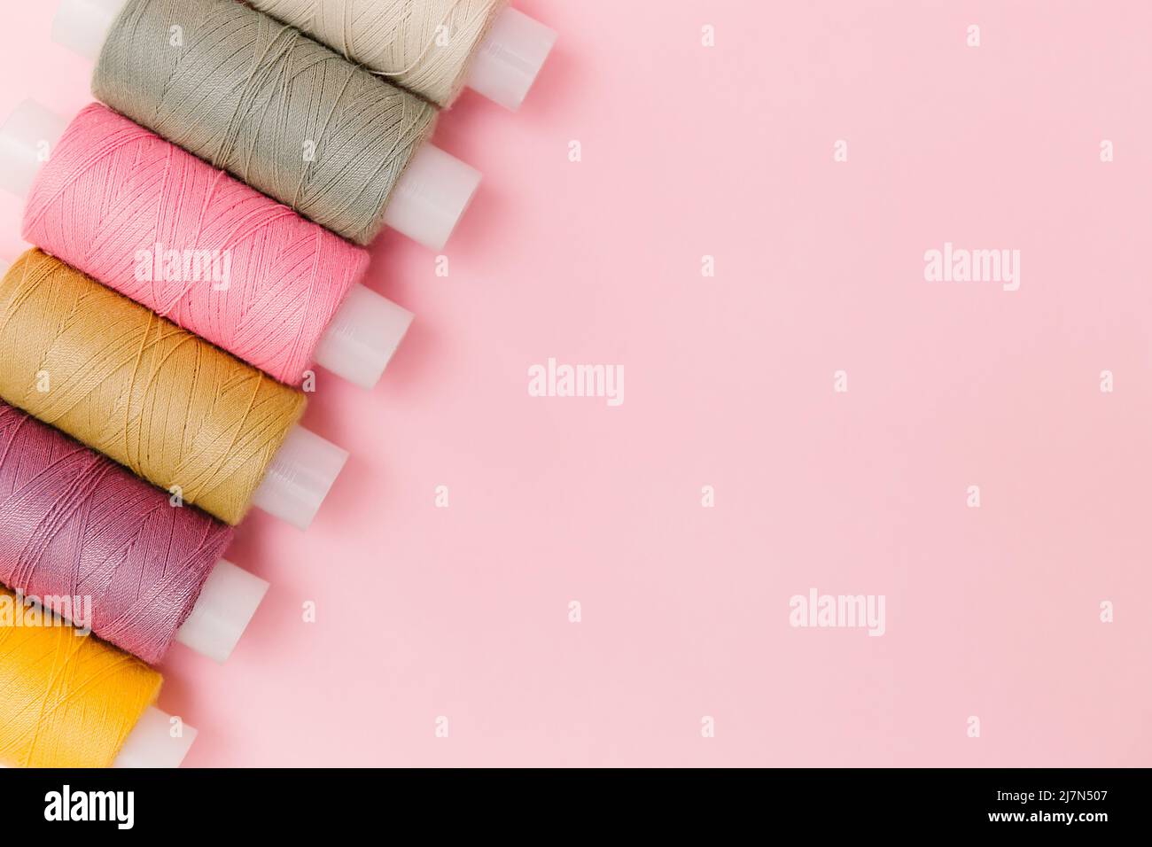 Sewing tools and sewing accessories on elegant pink background ...