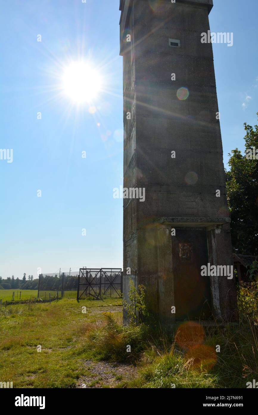 Lower part of an old border watchtower with a rusted entrance door on a ...