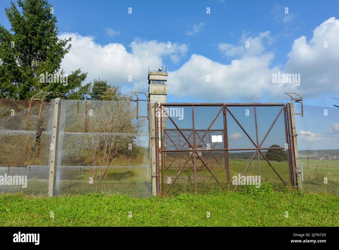 Barbed wire fence and a border watchtower on a former GDR border ...