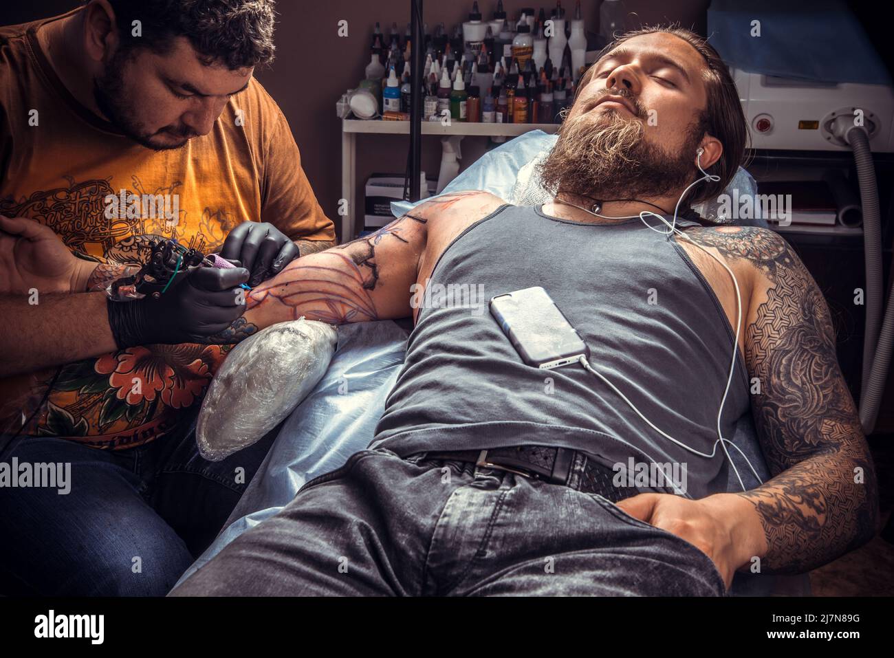 Professional tattooer working tattooing in tattoo studio Stock Photo ...