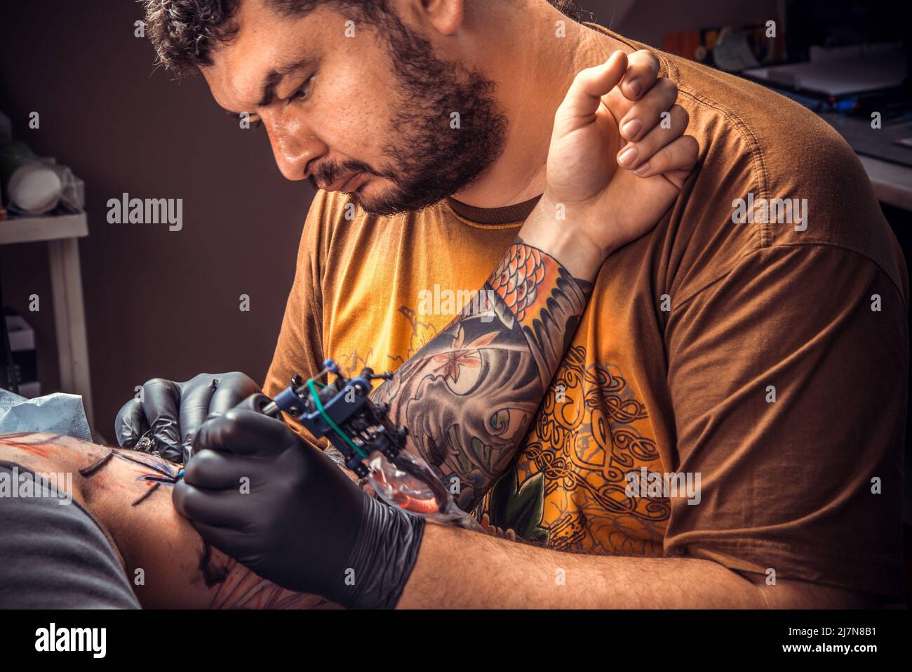 Tattooer at work in tattoo studio Stock Photo - Alamy