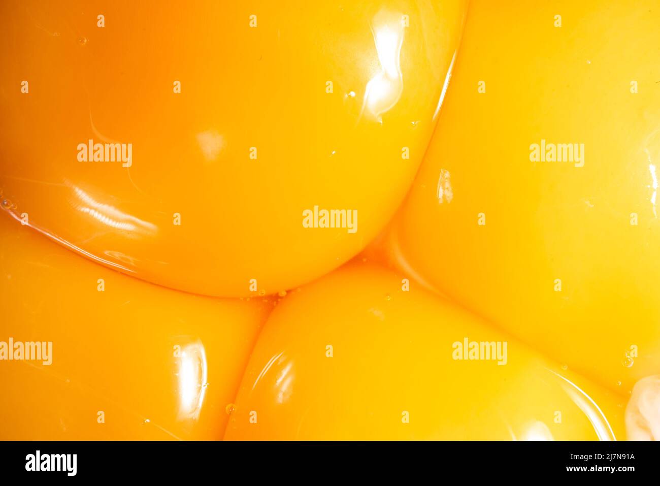 Close-up of egg yolks. Broken eggs and yolks next to each other. Smooth ...