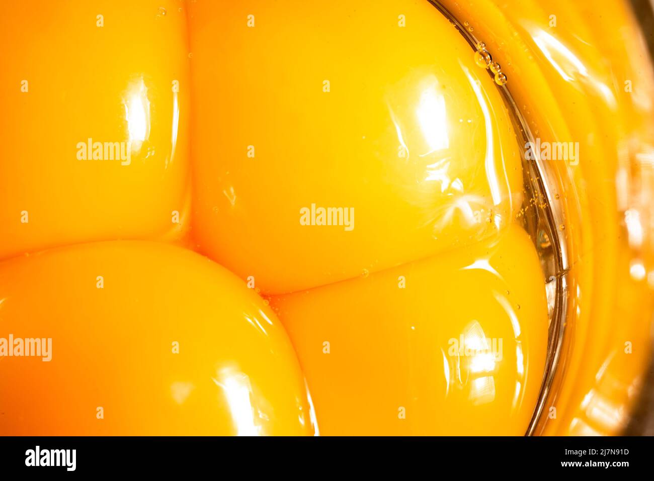 Close-up of egg yolks. Broken eggs and yolks next to each other. Smooth ...