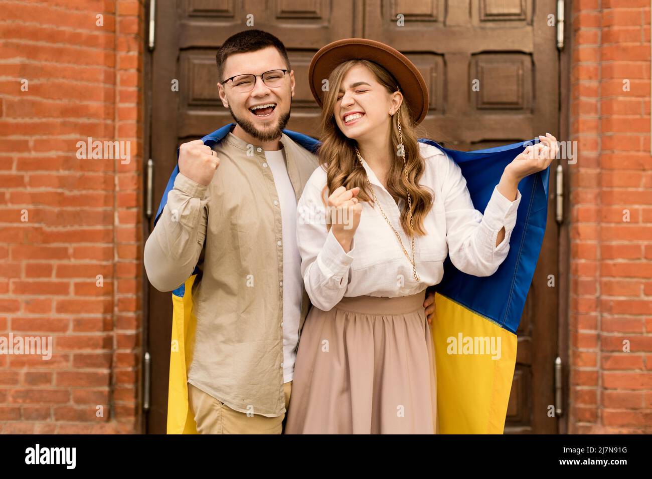 Emotional screaming couple hugging with the flag of Ukraine. Ukraine ...