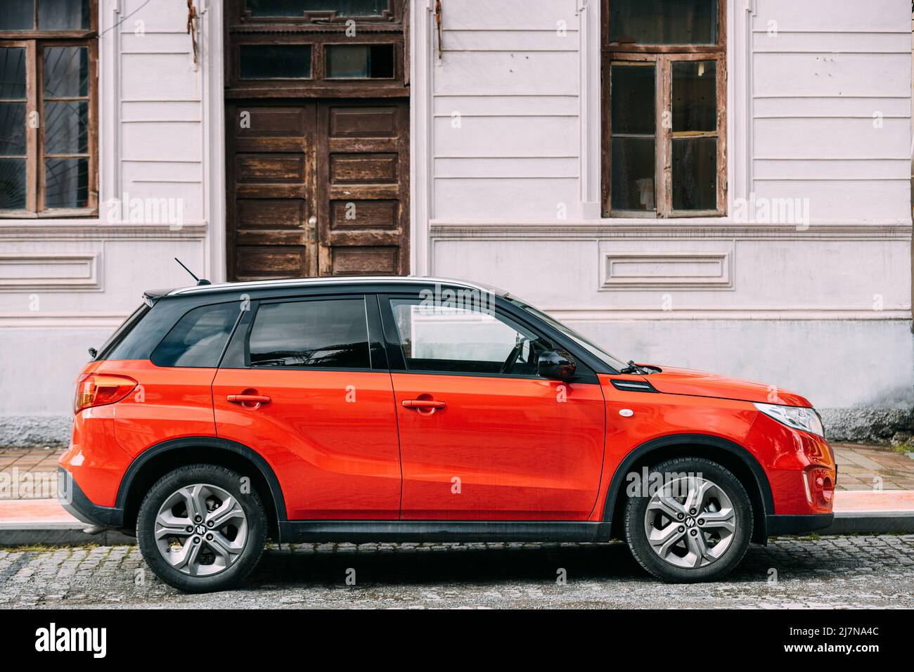 Red Suzuki Vitara car parked on street. Compact crossover SUV Stock ...