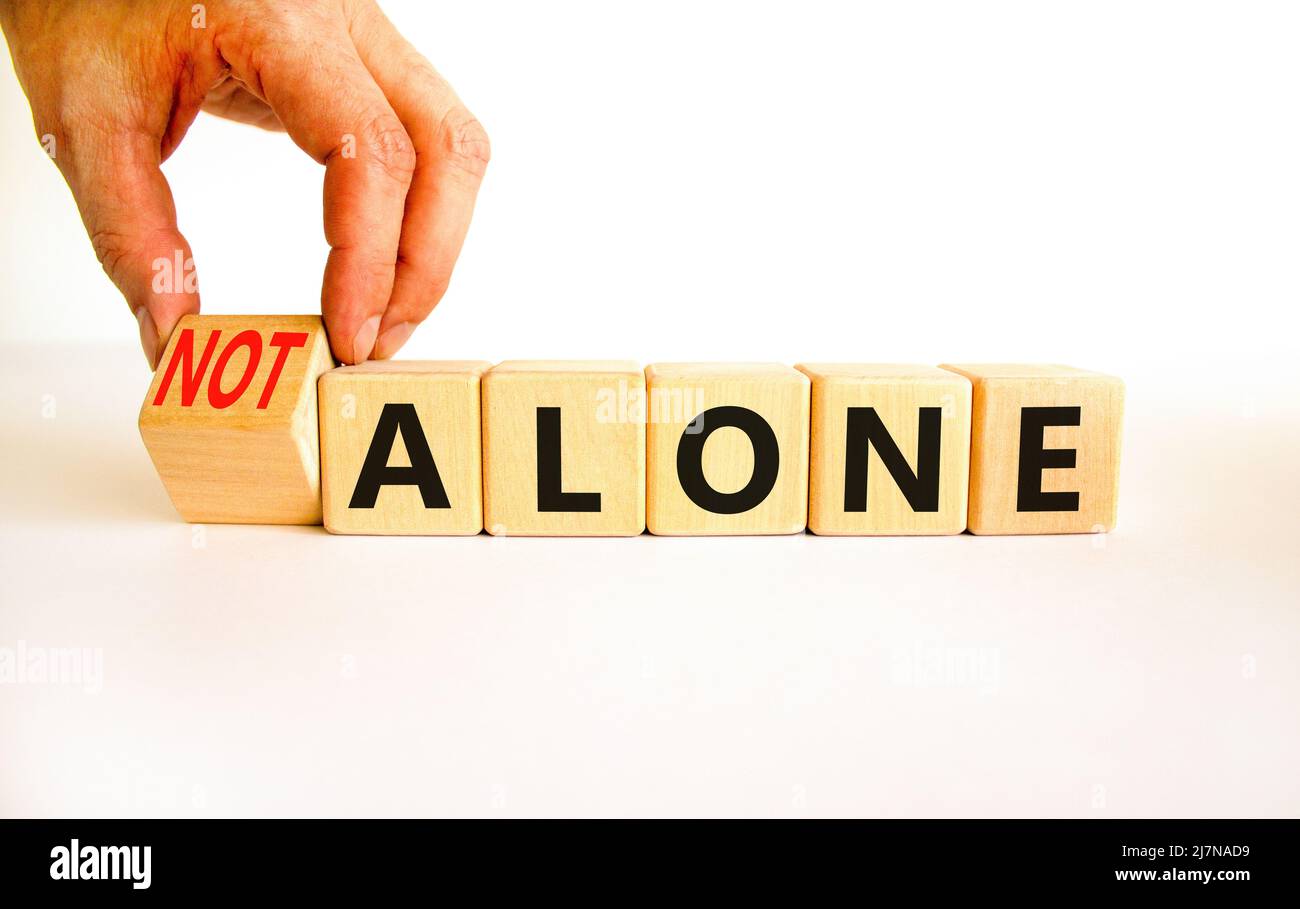 You are not alone symbol. Businessman turns wooden cubes and changes ...