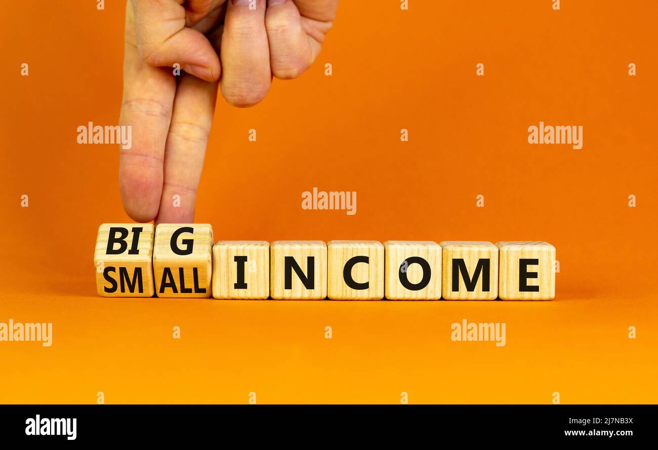 Big or small income symbol. Businessman turns wooden cubes and changes ...