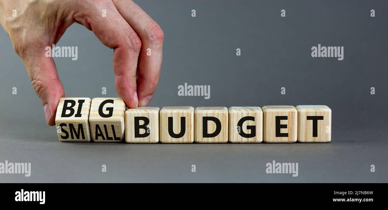 Big or small budget symbol. Businessman turns wooden cubes and changes ...
