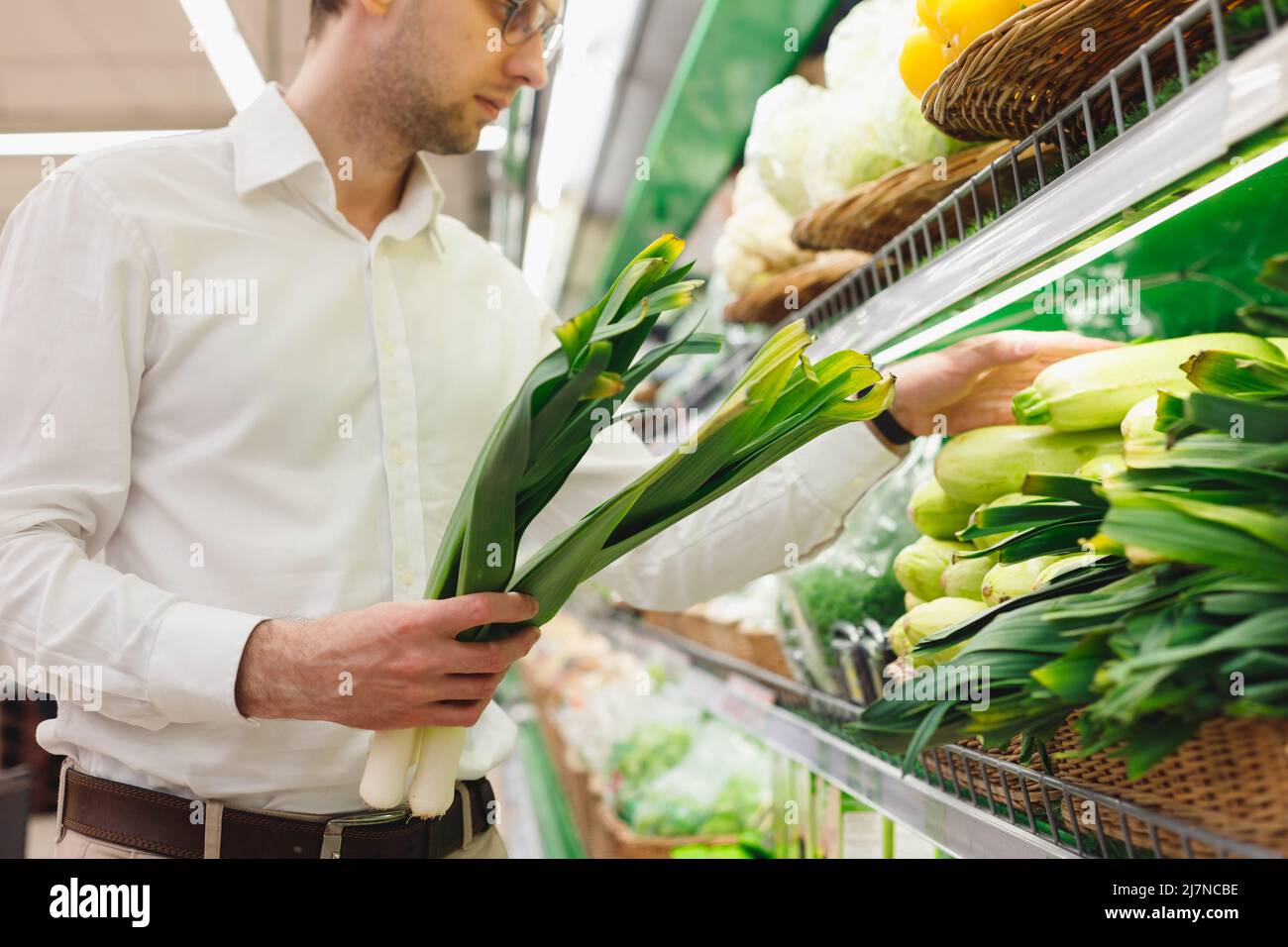 man hand holding leek in grocery store in supermarket Stock Photo - Alamy