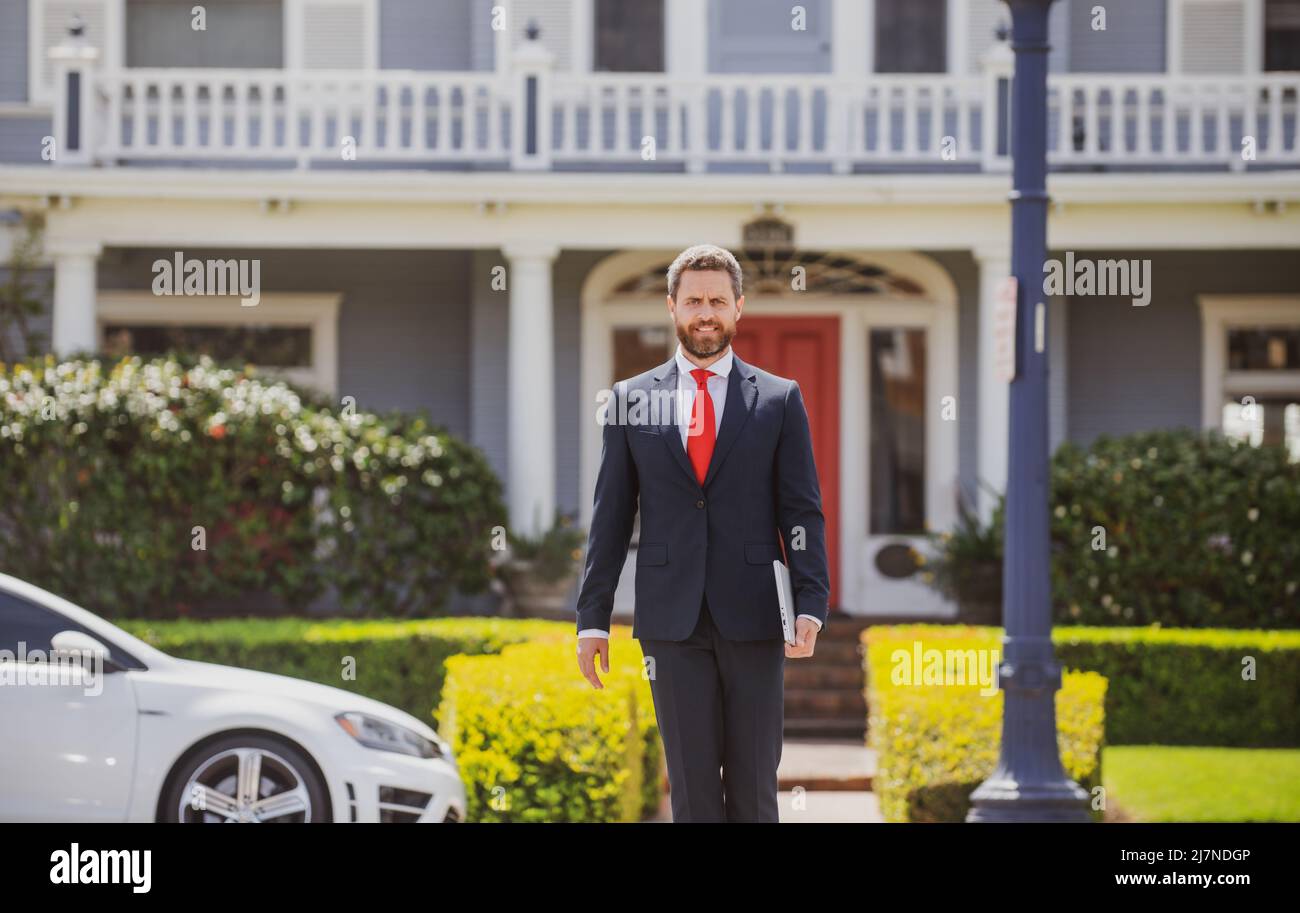 Real estate. Agent ready to sell home. Businessman standing outside a ...